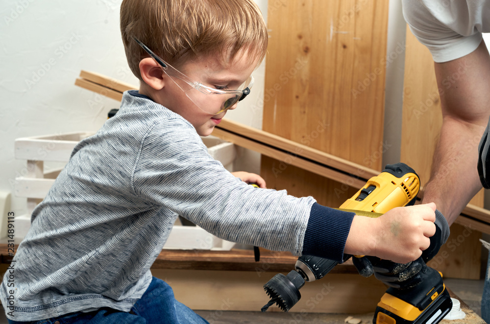 Family time: Dad shows his son hand tools, a yellow screwdriver and a ...
