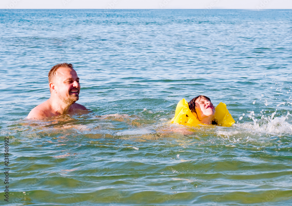 Fatherhood concept. Father stand near, teaches his son to swim. Dad and ...