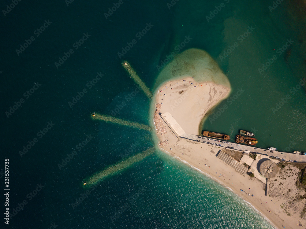 Port and jetty, sandy peninsula with old, rusty ships, birds eye view ...