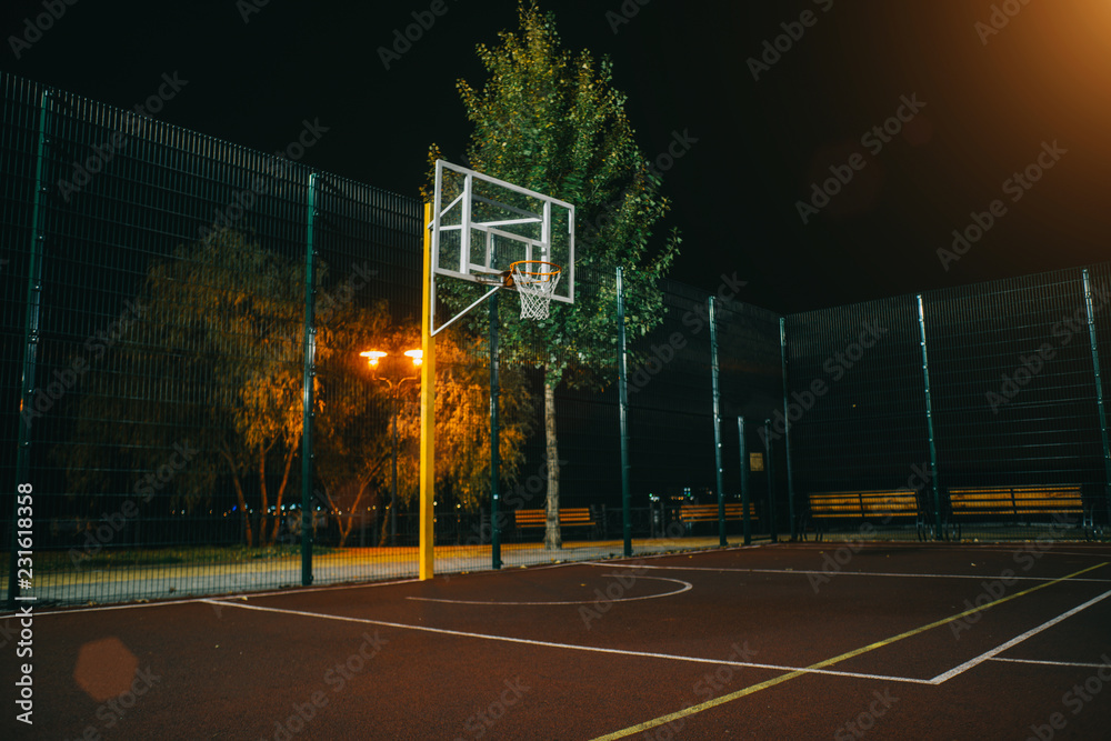 Illuminated basketball playground with red pavement, modern new ...