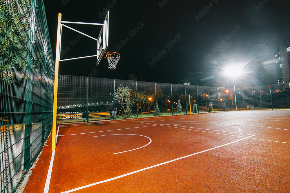 Illuminated basketball playground with red pavement, modern new ...