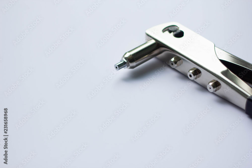 Detail of an old rivet gun (hand riveter) with rivets on a white ...