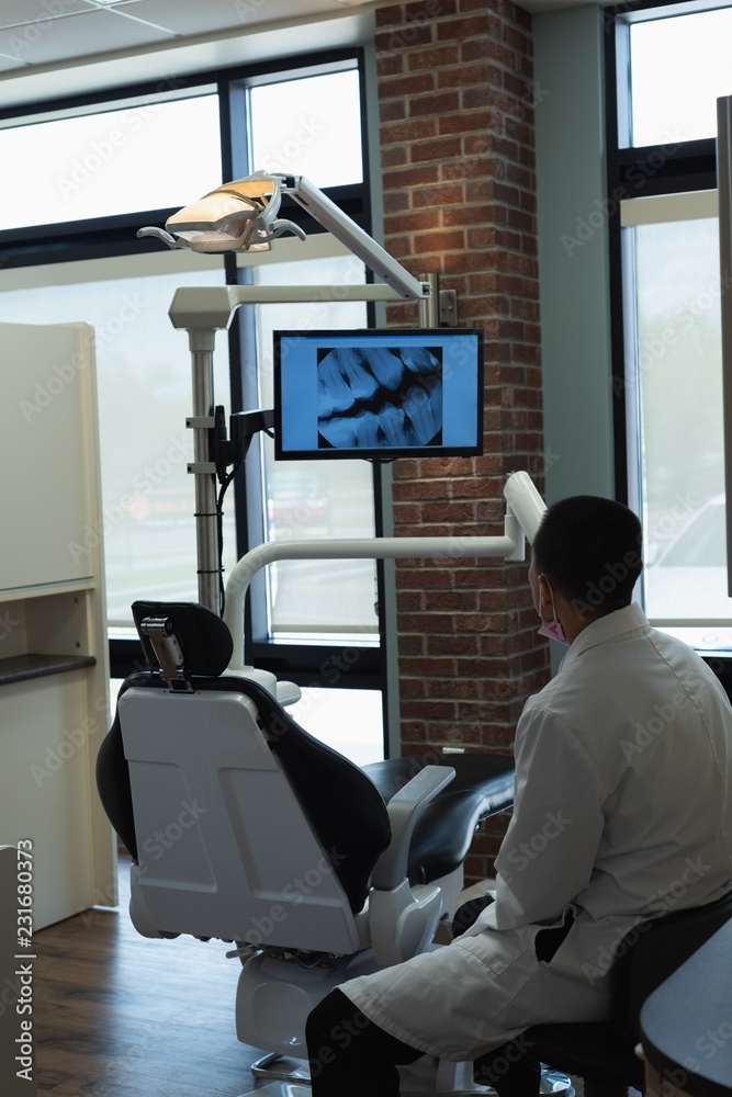 Male dentist looking at x-ray screen in clinic Stock Photo | Adobe Stock