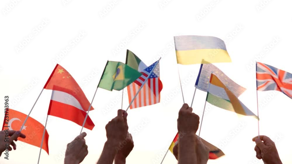 Different flags in human hands. People of different nationalities ...