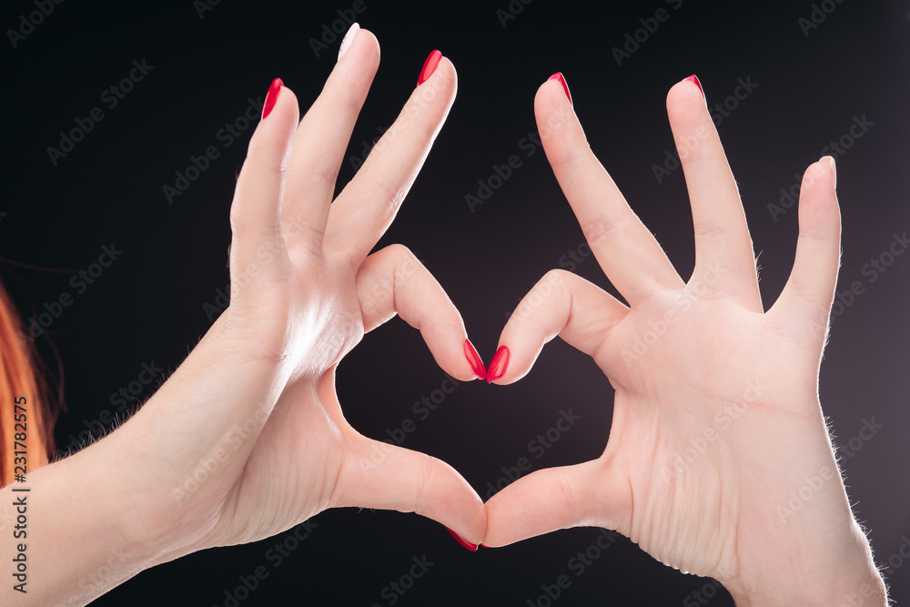 Crop of two hadns together showing heart by fingers and gesturing ...