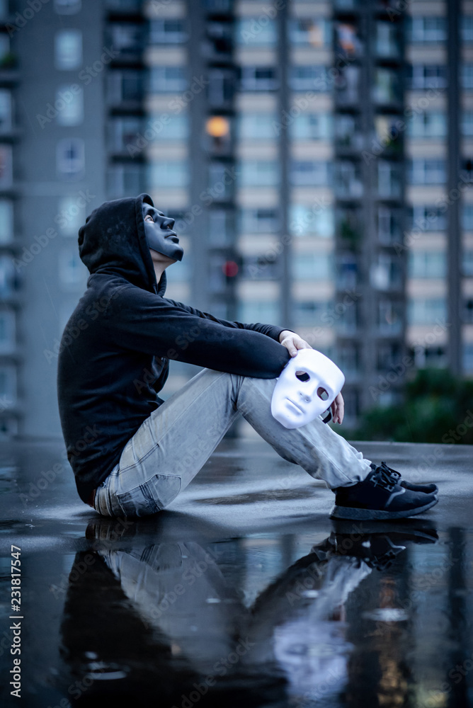 Reflection of mystery hoodie man with black mask holding white mask ...