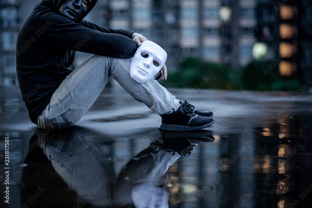Reflection of mystery hoodie man with black mask holding white mask ...