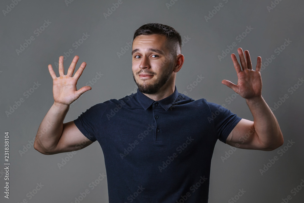 Studio portrait of a young man keep hands up before him with the ...