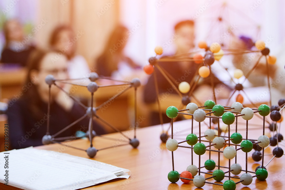 School children in a science class with a molecular model. Background ...