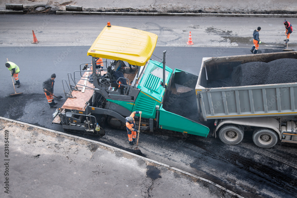 Asphalt paver machine or paver finisher and road construction workers ...