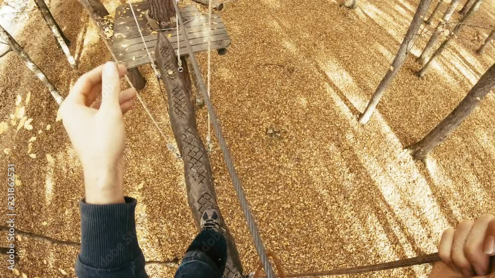 Person POV walk over snake bridge high between trees 4K. Camera on a ...
