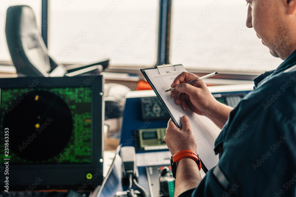 Marine navigational officer or chief mate on navigation watch on ship ...