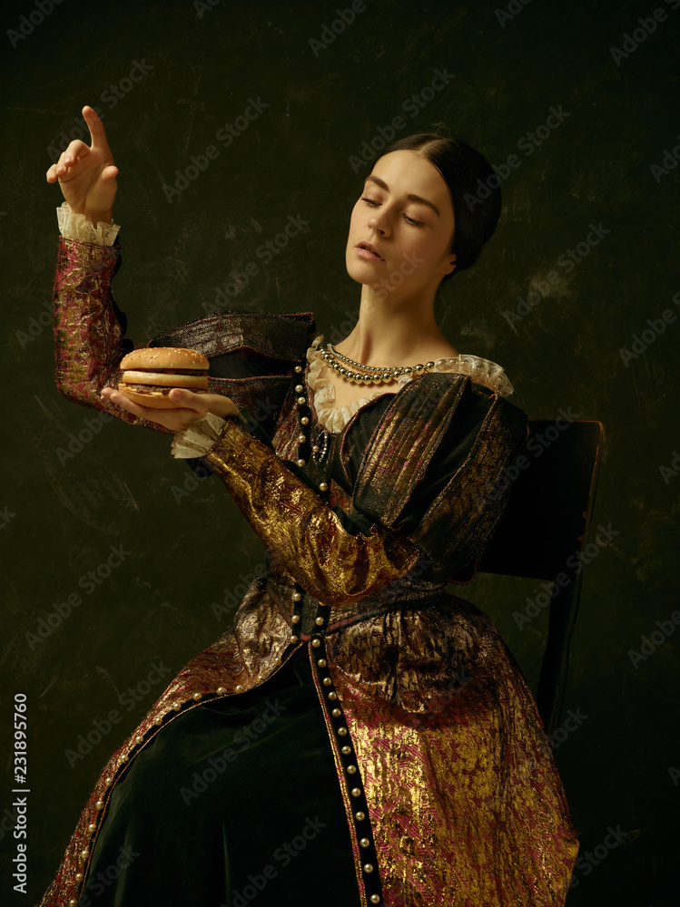 Portrait of a girl wearing a princess or countess dress over dark ...