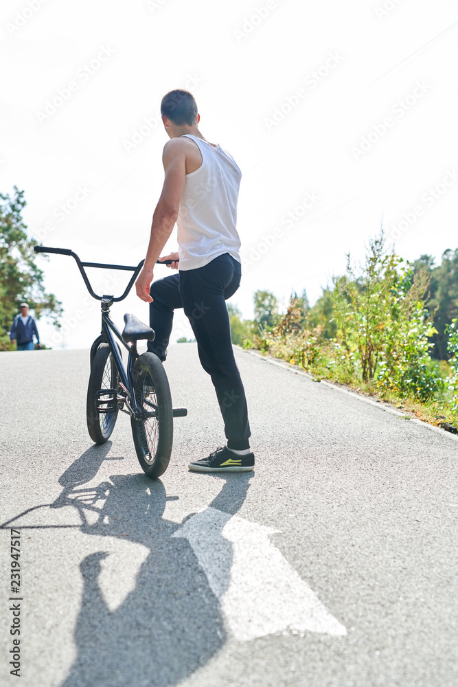 Full length back view portrait of muscular young man standing on hill ...