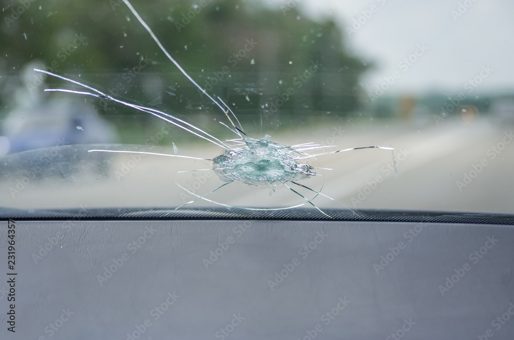 The broken windshield of the car from flying stone. The hole in the ...