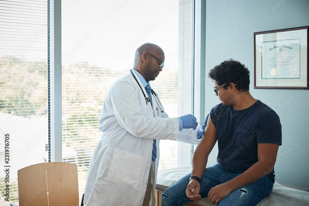 Doctor giving an injection to a patient Stock Photo | Adobe Stock