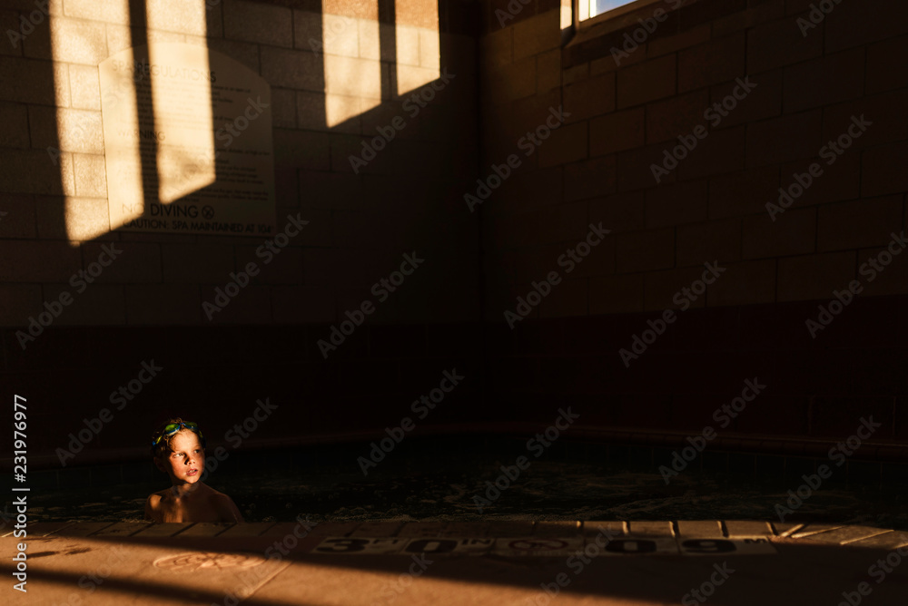 Boy swimming in a swimming pool in the shadows Stock Photo | Adobe Stock