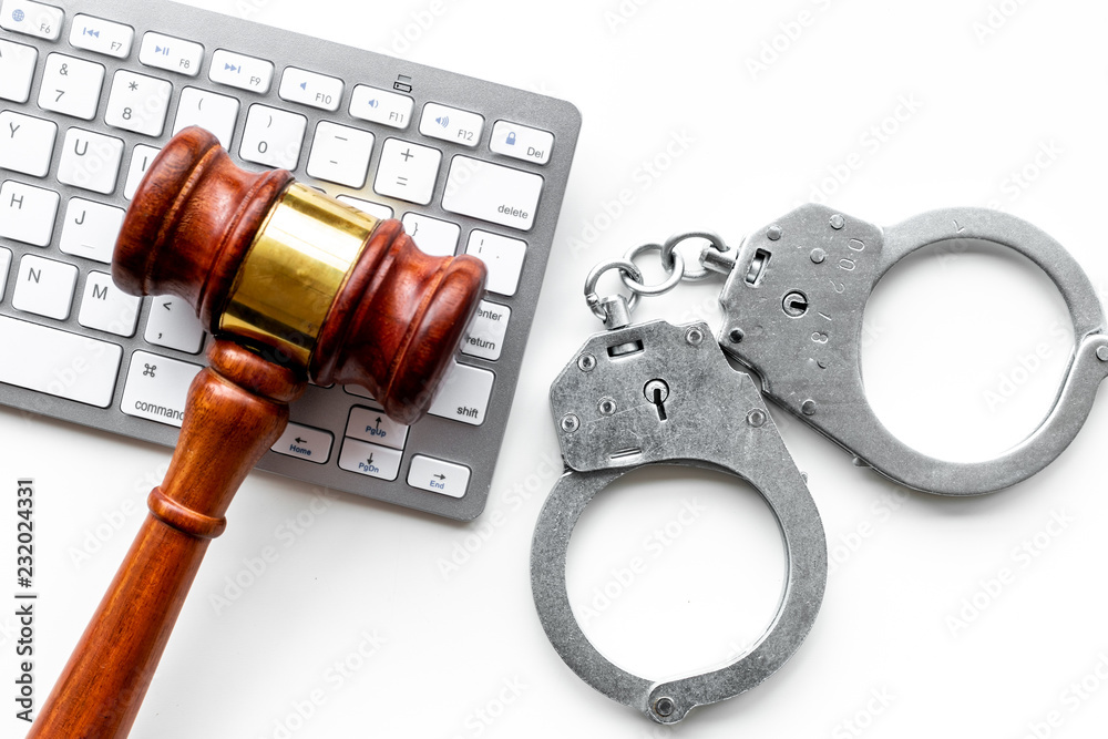 Arrest of a hacker for cyber fraud concept. Handcuff near keyboard and ...