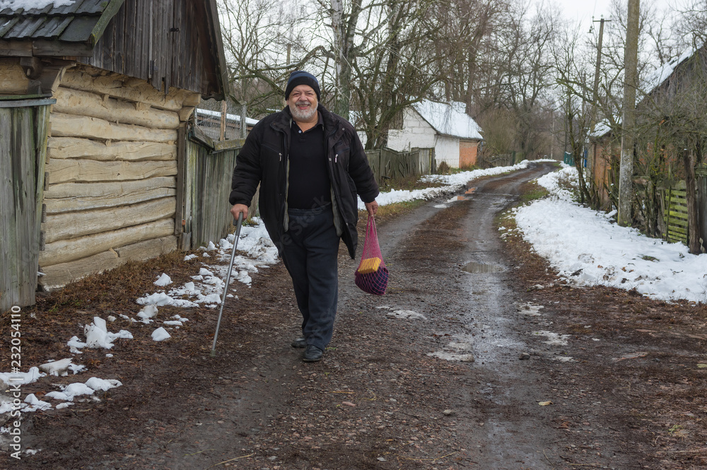 Happy and smiling elderly peasant walking on an empty street of rural ...