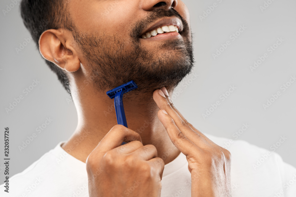 grooming and people concept - close up of young indian man shaving ...