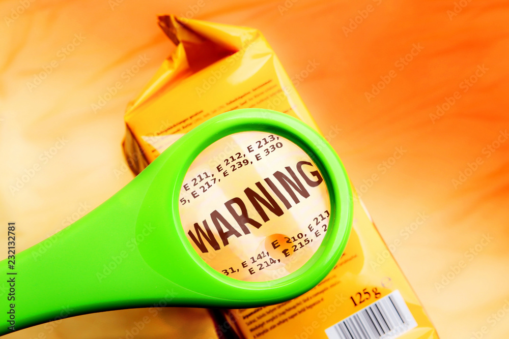 Magnifying glass on food additives label with word warning. Concept ...