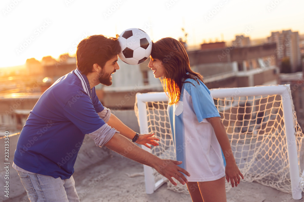 Couple balancing with a football between their heads Stock Photo ...