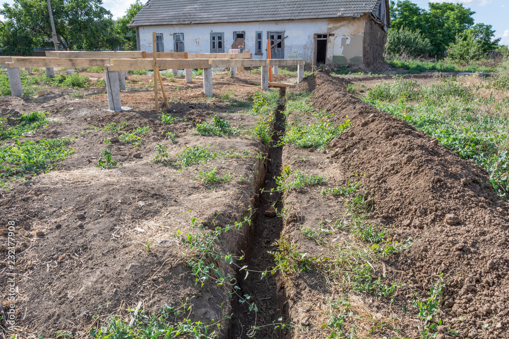 Trench for laying plumbing pipes. Stages of construction of the frame ...
