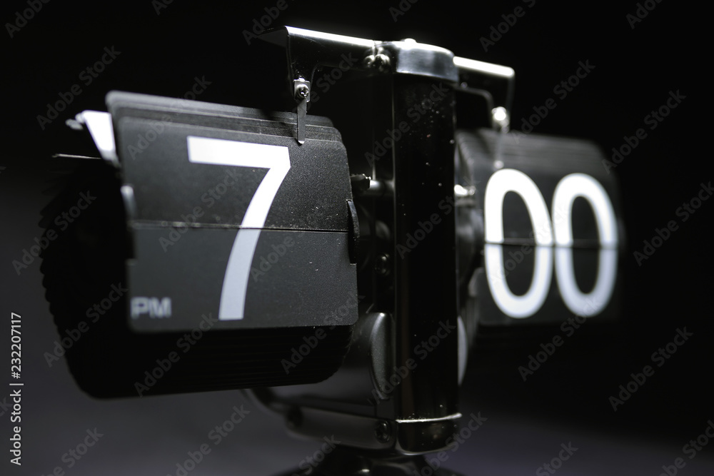 Classic flip clock watch face showing hour and minutes set to 7:00 PM ...