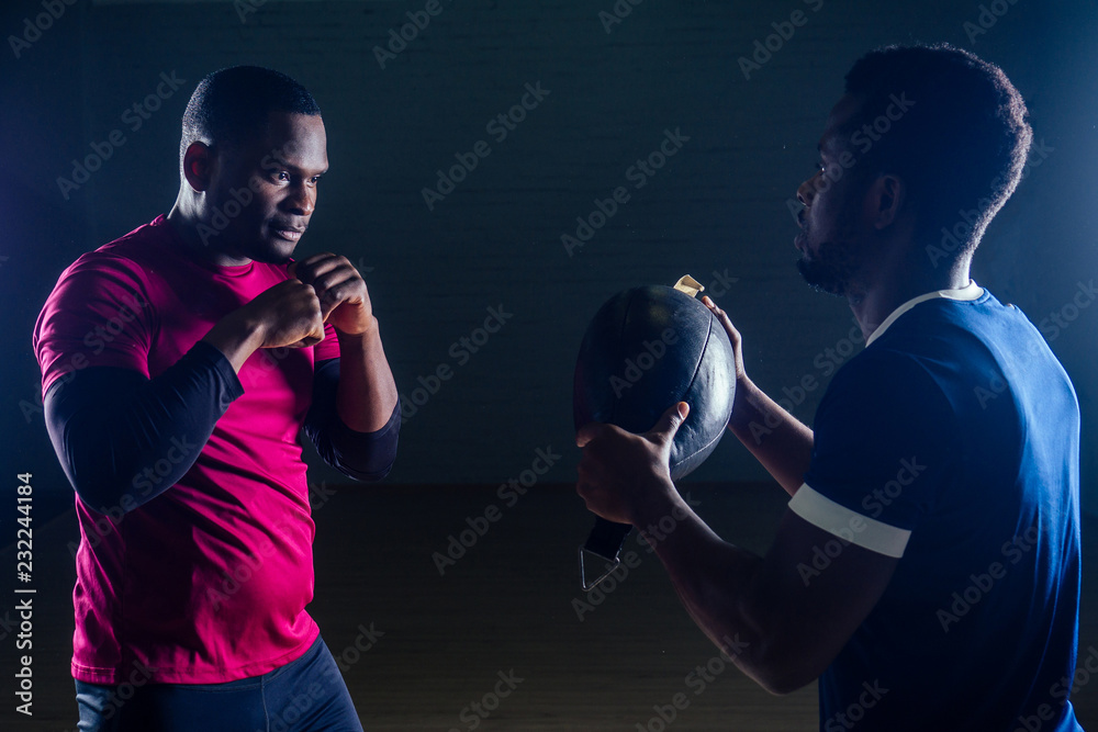 team work two handsome african american sportsman in boxing on a black ...