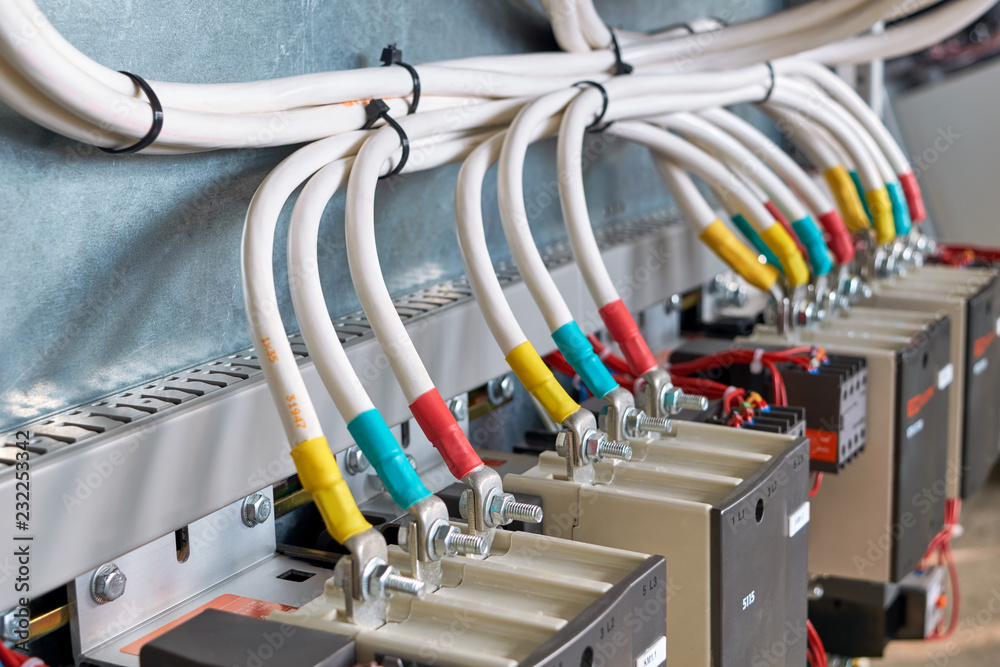 A large bundle of electrical cables or wires connected to contactors ...