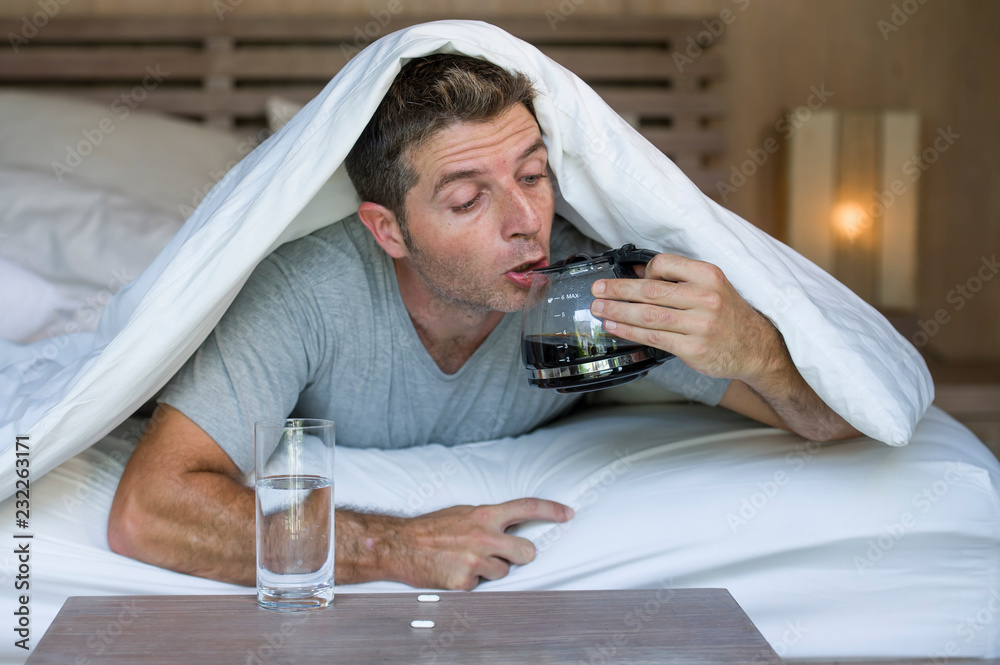 lifestyle home portrait of young exhausted and wasted man waking up ...