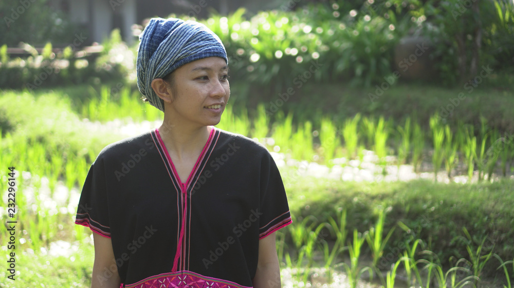 Asian ethnic woman with native dress smile at her organic rice field ...