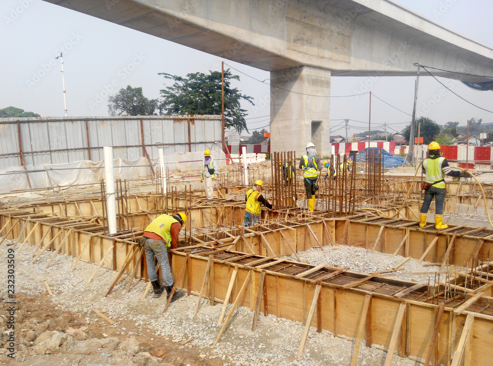 Ground beam form work constructed by workers at the construction site ...