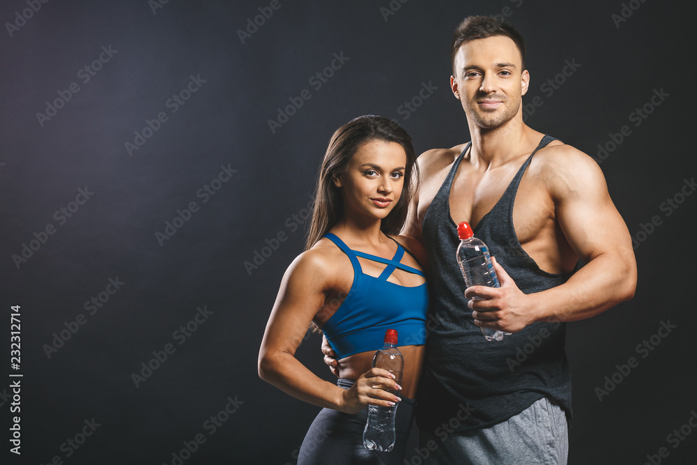 Happy smiling fitness couple on a black background. Stock Photo | Adobe ...