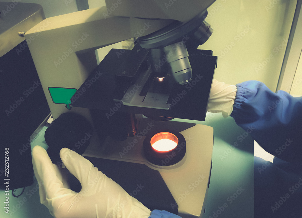 Blurred of scientist being used the microscope to view the appearance ...