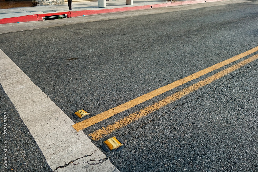 Parallel center lines and a red curb meeting a crosswalk. Stock Photo ...