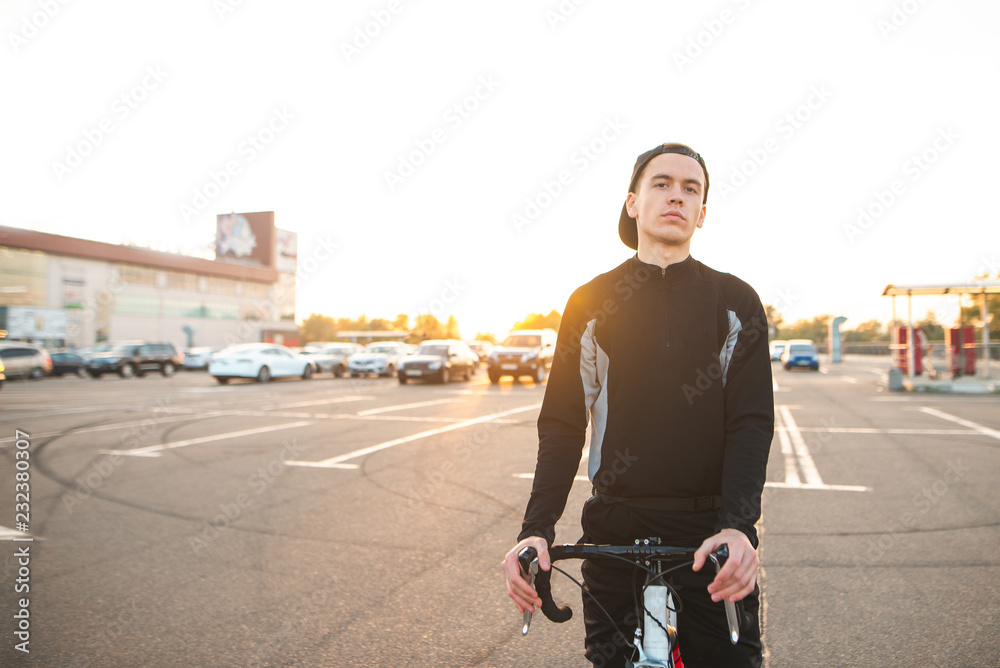 Portrait of an attractive bicycle rider standing with a bike on the ...