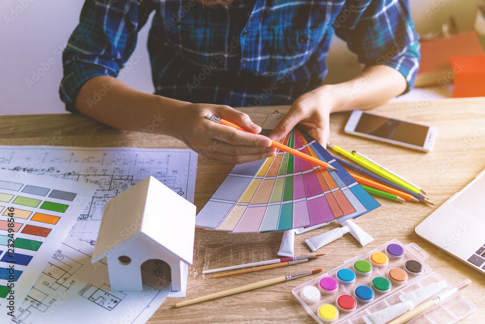 Architect design holding a home model for choosing color samples swatch ...