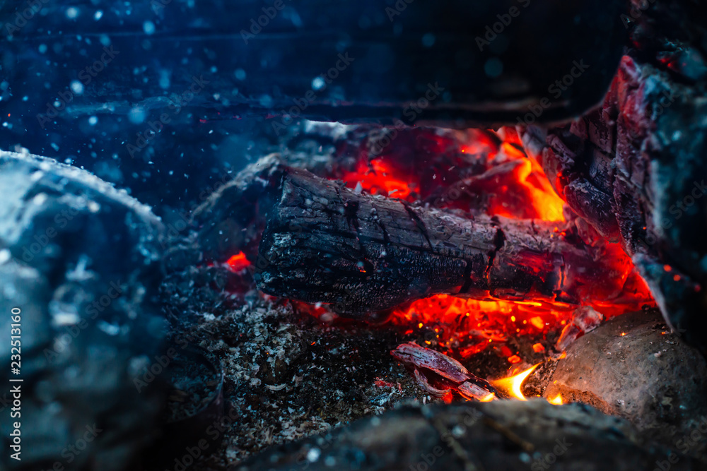 Smoldered logs burned in vivid fire. Atmospheric background with orange ...
