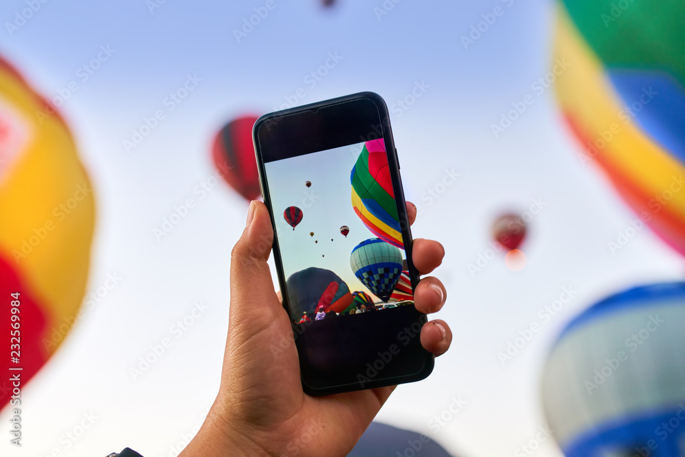 Handing holding a cell phone camera at balloon festival Stock Photo ...