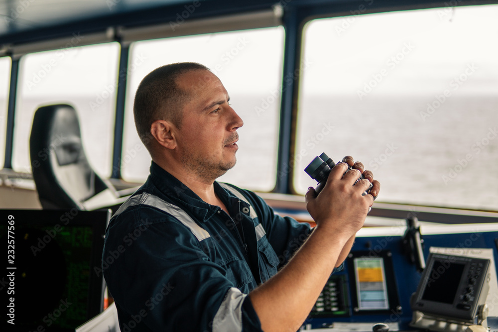 Navigational officer lookout on navigation watch looking through ...