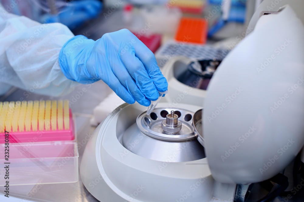 Dna test in the lab. a laboratory technician with a dispenser in his ...