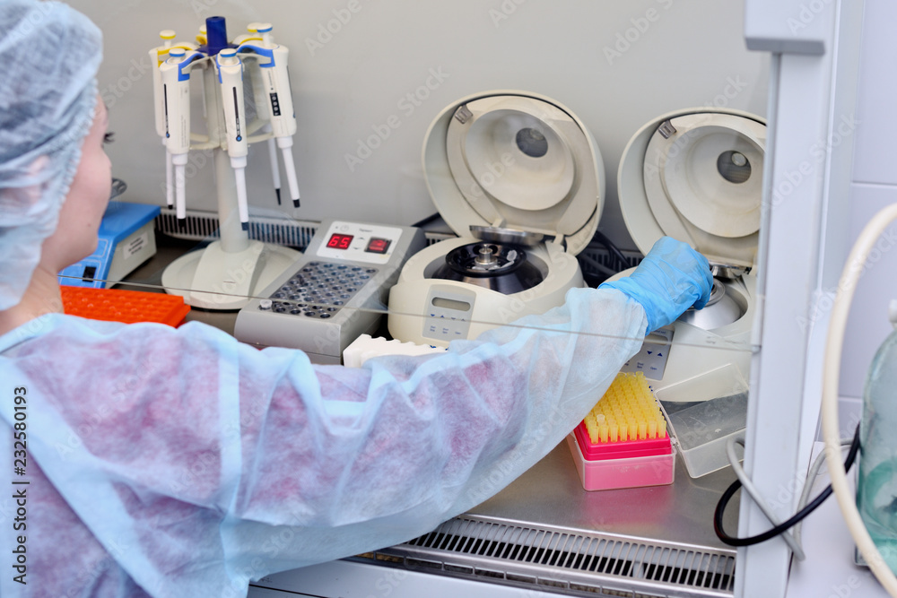 Dna test in the lab. a laboratory technician with a dispenser in his ...