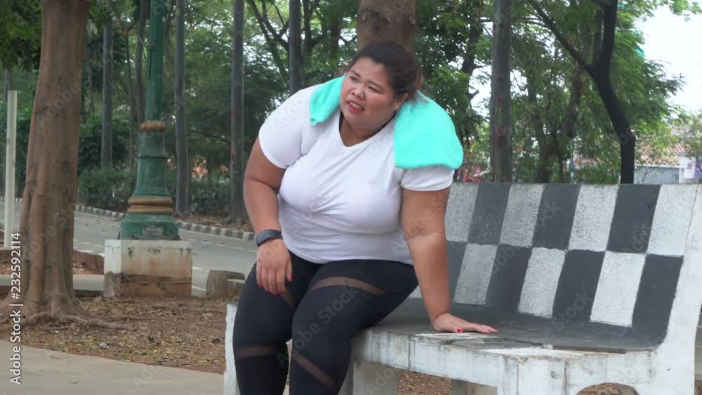 Exhausted Overweight Woman Sitting On Bench With Breathless After