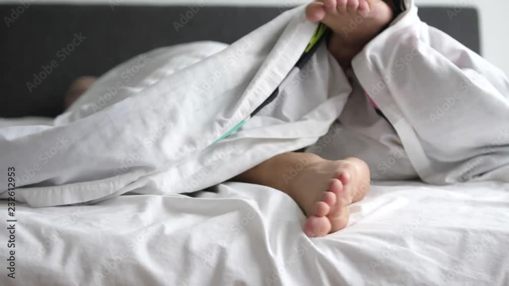 Man sleeping in bed feet relax on holidays peeking out his feet from ...