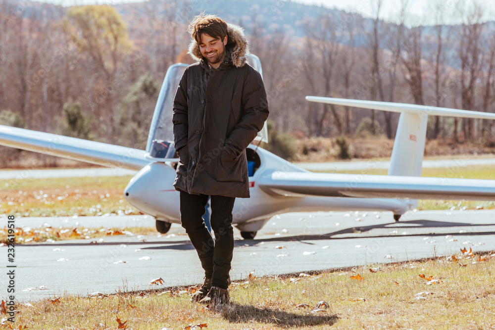 Smiling man walking from his glider flight on an airfield Stock Photo ...
