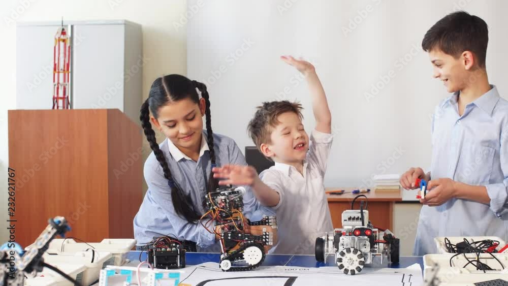 Group of happy kids of different age choose parts of robotic electric ...