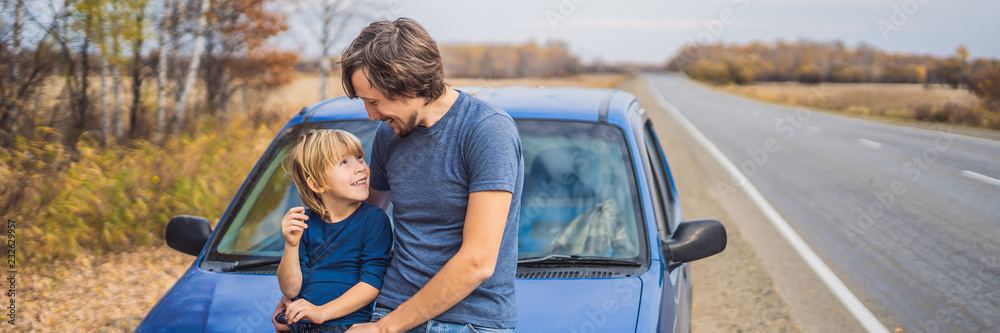 Dad and son are resting on the side of the road on a road trip. Road ...