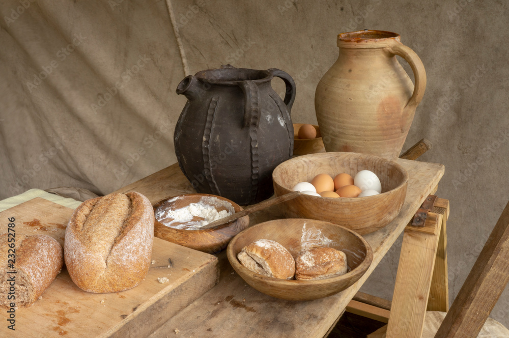 Medieval jugs and bowls full of bread and eggs. Stock Photo | Adobe Stock