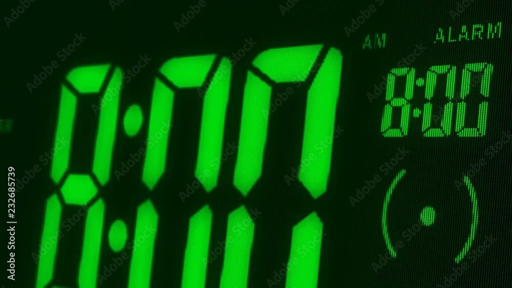 Digital alarm clock waking up at 8 AM. Close-up LED display. The ...
